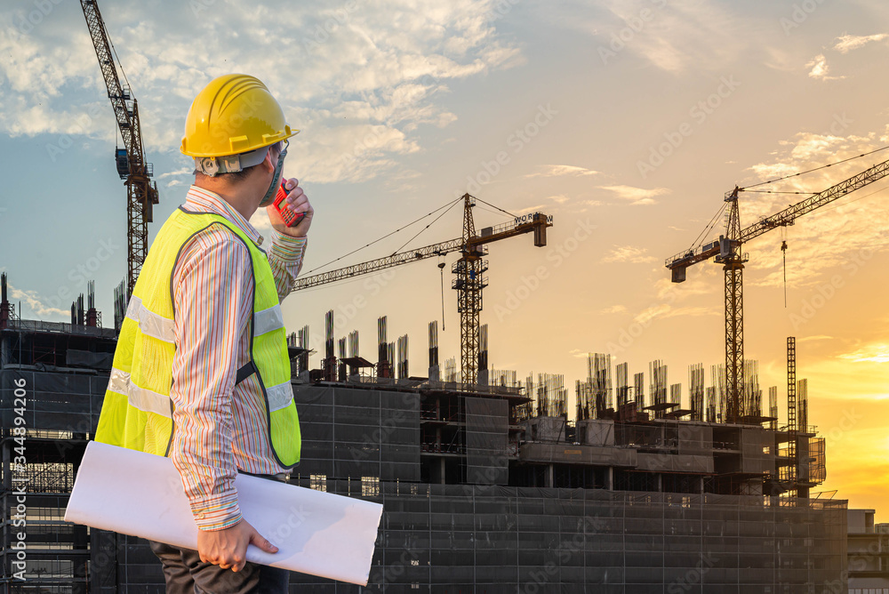 An Asian white engineer wore a suit and a safety hat on his head and ...