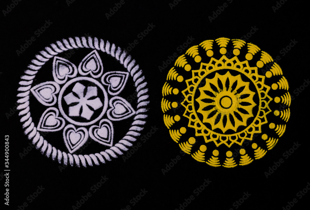 top view of white rangoli art and beautiful yellow rangoli with black ...