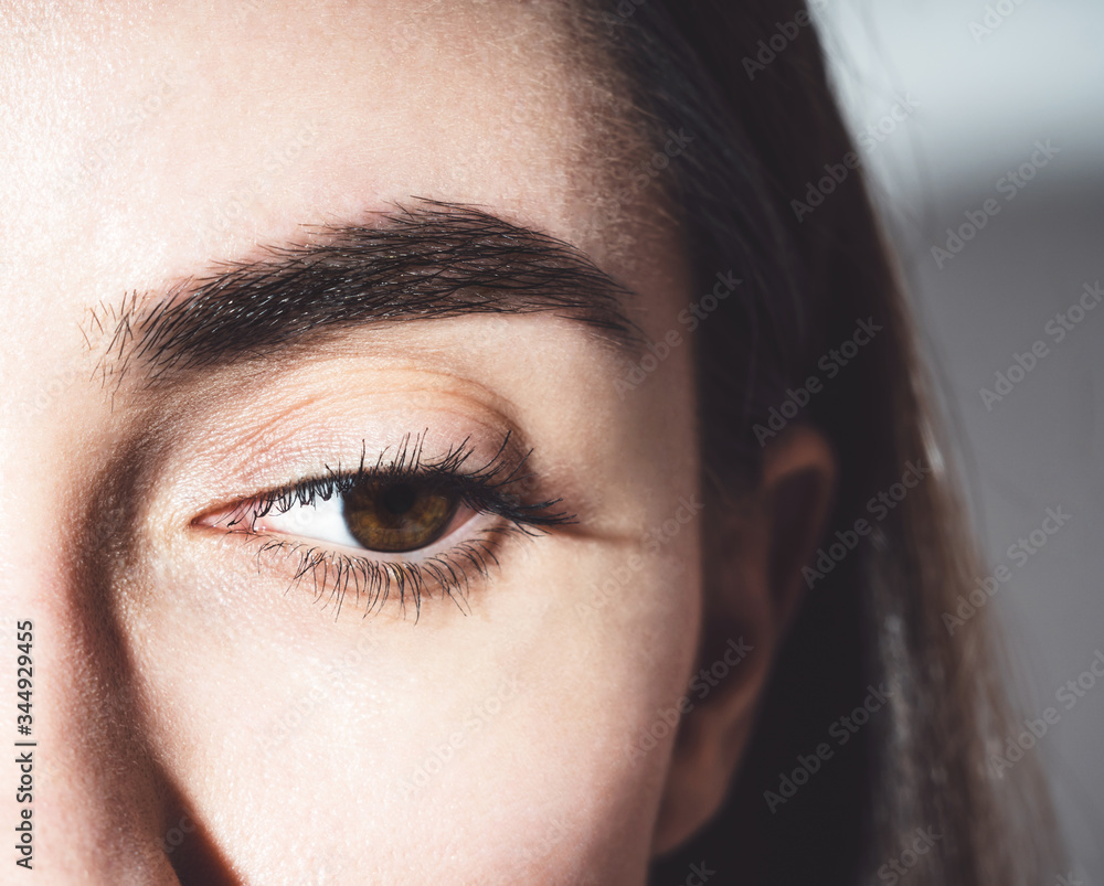 Beautiful female eye. One brown eye close-up. The eye is looking down ...