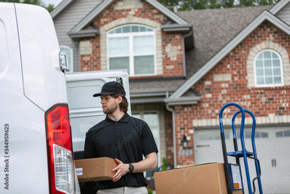Shipment: Man Putting Box Onto Stack On Dolly Stock Photo | Adobe Stock
