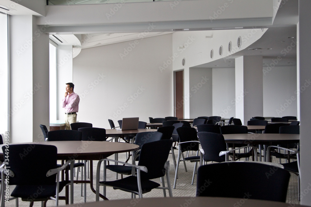 Thoughtful businessman looking through window in office Stock Photo ...