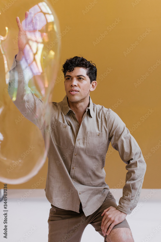 young man touching large bubble as it floats in front of him Stock ...