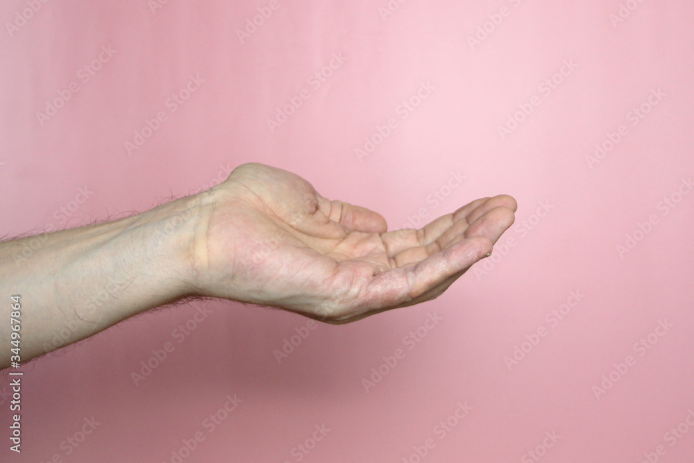 Male hand with fair skin shows a gesture, hand on a light pink ...