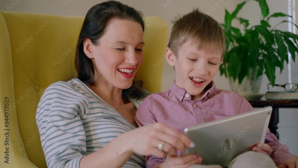 Mother and son using digital tablet together Spbas. watch video cartoon ...