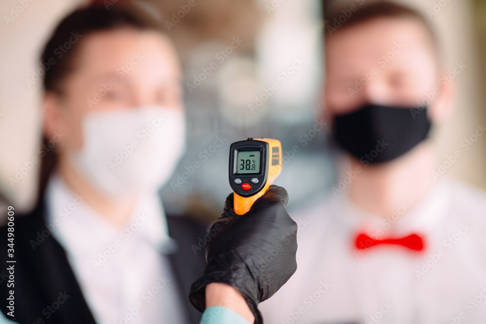 The Manager of a restaurant or hotel checks the body temperature of the ...