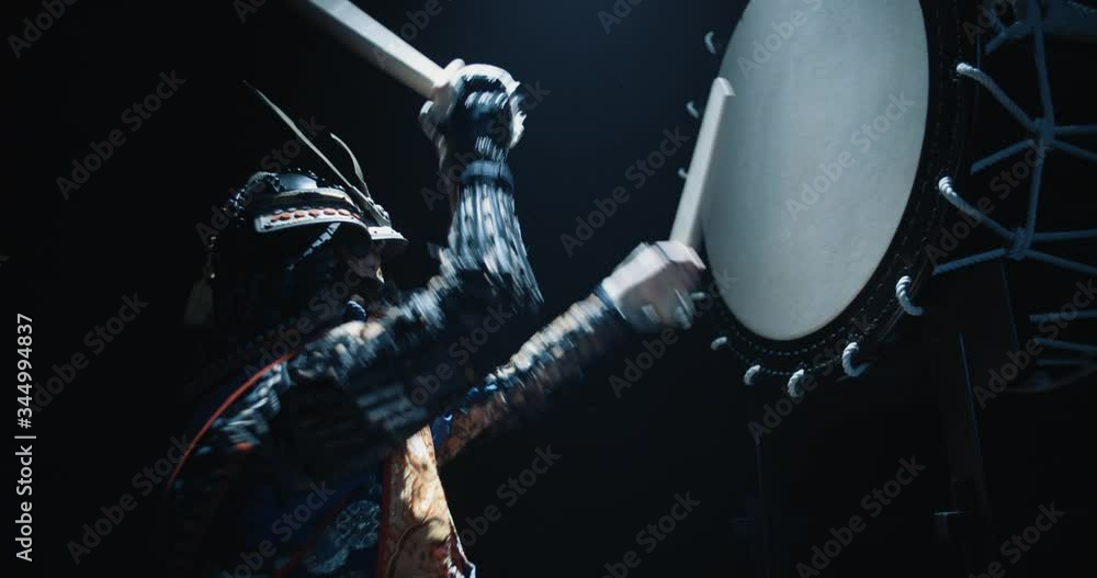 Japanese man in historical samurai costume playing on taiko drum with ...