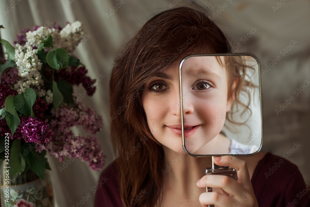 Mothers Day. Mom sees her daughter in the mirror, like a reflection of ...