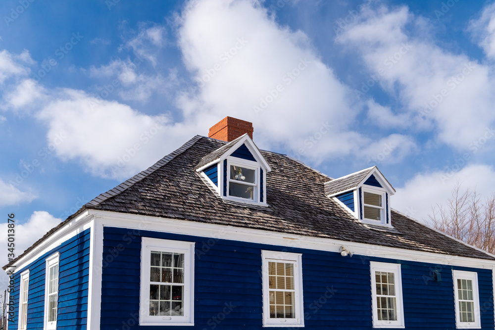 Navy blue vintage building with white trim and dark roof shingles. The ...