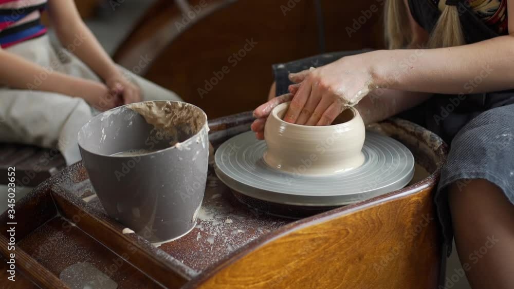 Close up of Art Teacher Showing How to Create a Ceramic Pot to a Little ...