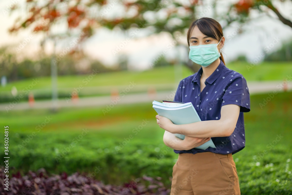 Portrait Young Asian student girl wearing medical mask and holding ...