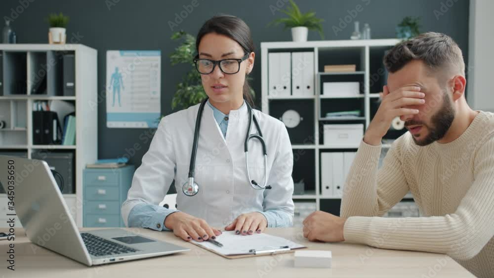 Caring doctor holding patient's hand after giving bad news talking in ...