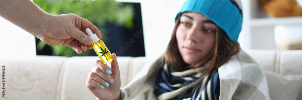 Focus on male hand giving bottle of medication to woman. Ill lady ...