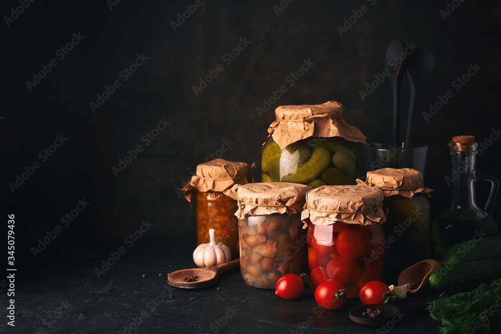 Vegetables and fruits canning. Glass jars with fermented, pickled and ...