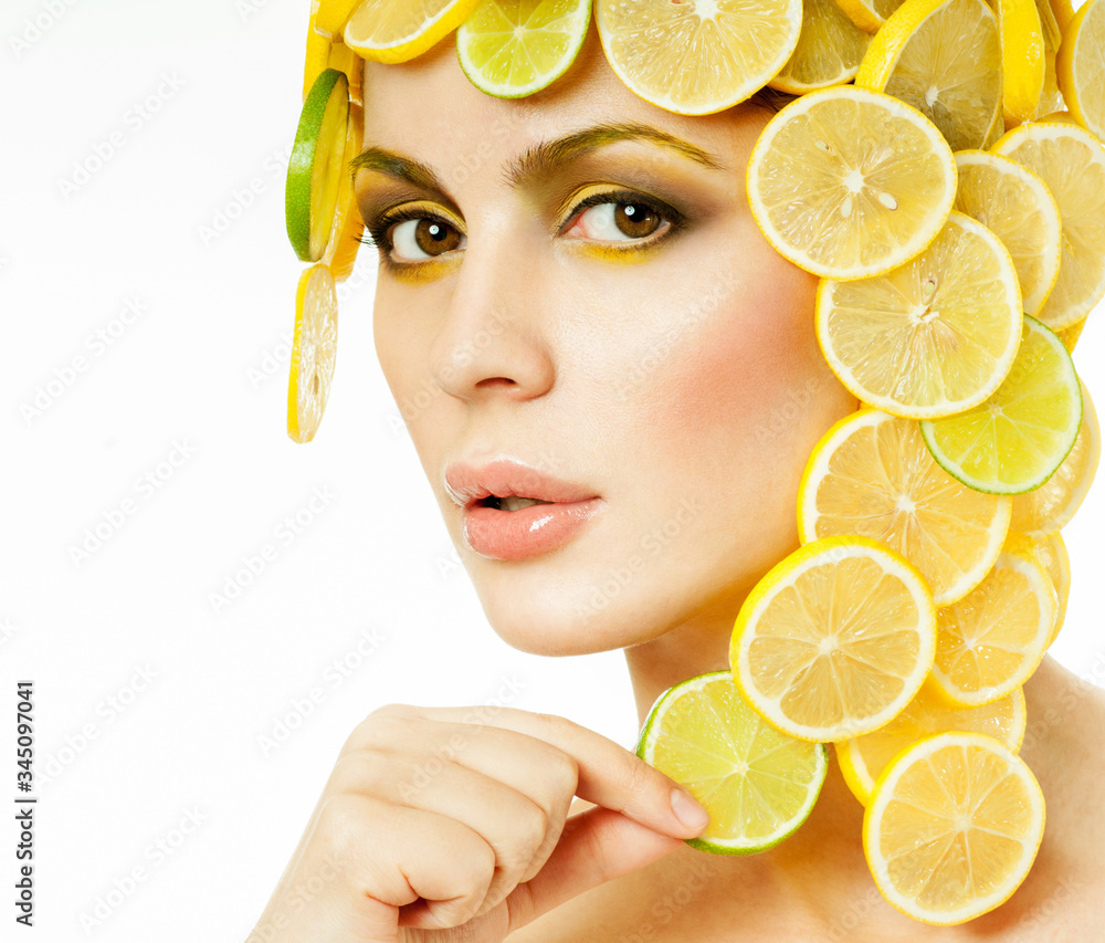 Beautiful woman with juicy lemons and limes in her hair. Perfect skin ...
