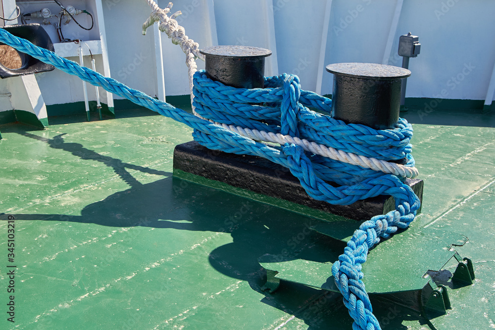 Ship is moored to the berth using a nylon rope tied to a bollard. Stock ...