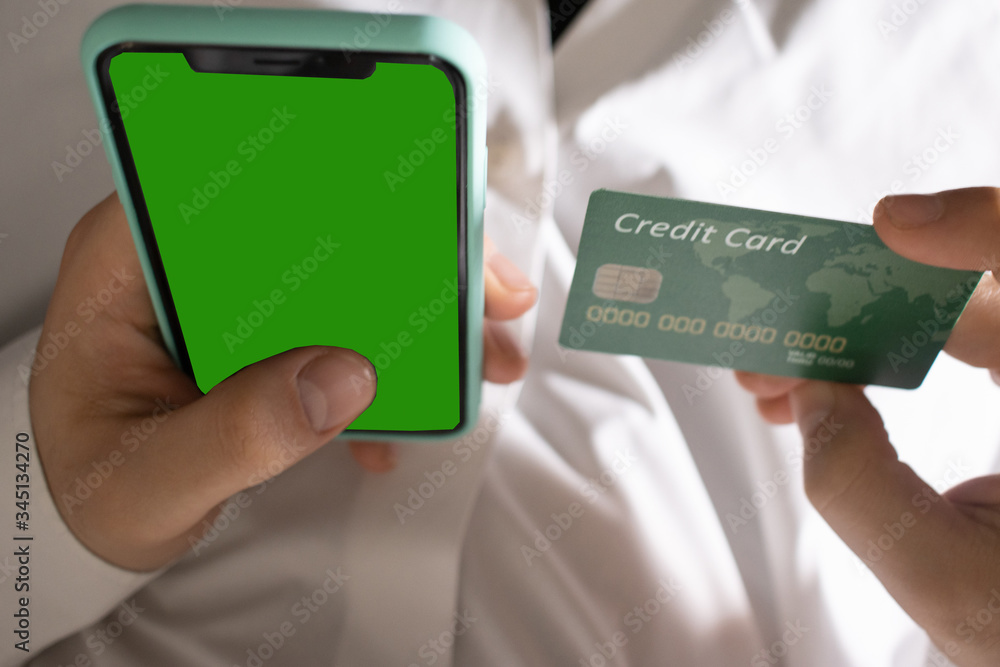 A black smartphone with green screen for chroma key compositing and a ...