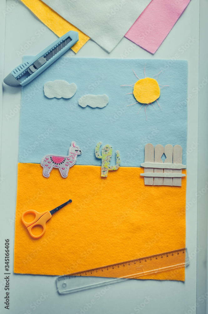 Kid is making a collage. Cutting shapes from colored paper to glue it ...