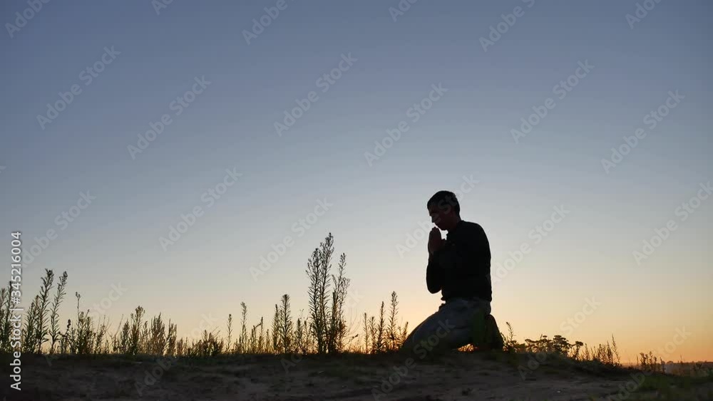 man praying kneeling reads a praying believes in god. faith concept ...