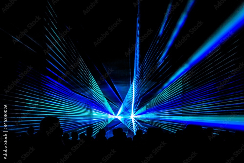 Blue laser show nightlife club stage with party people crowd. Luxury ...