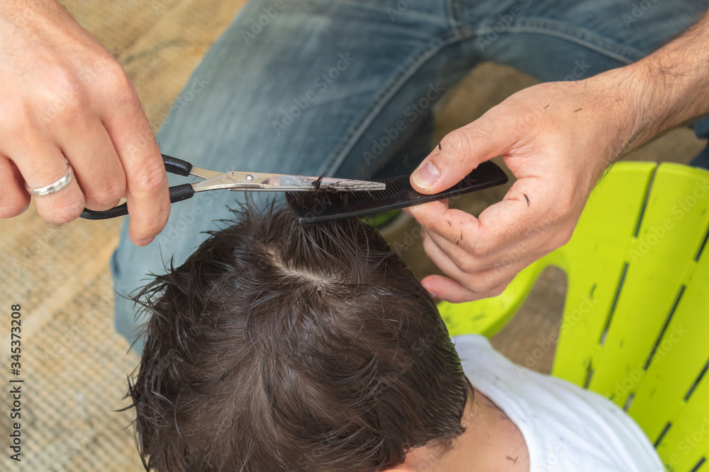 Father cutting son's hair at home during confinement by covid-19 Stock ...