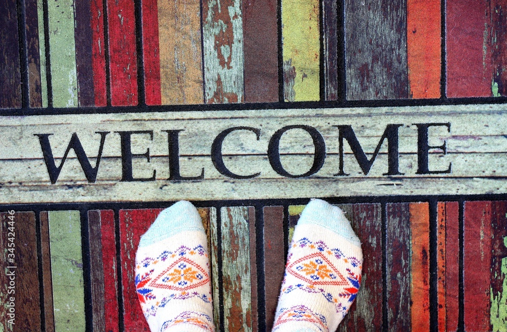 Feet are on the mat. Warm woolen socks with various patterns are ...