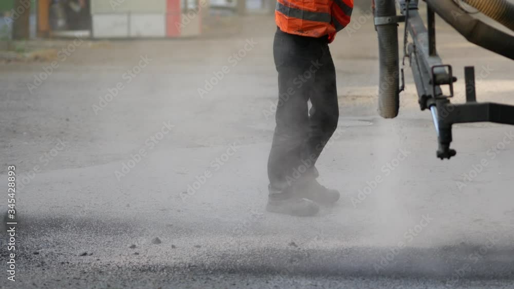 Vídeo do Stock: Workers perform minor repairs to pavement by spraying ...