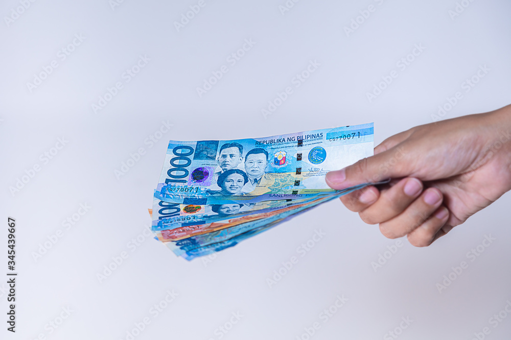 Fan of Philippines peso banknotes in female hand. Woman's hands show ...