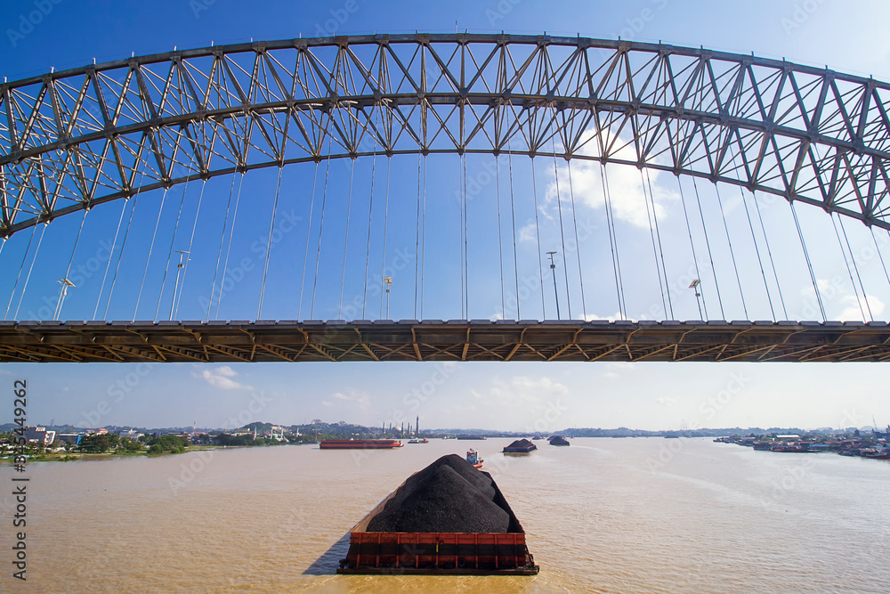 coal barge passing under mahakam bridge, Samarinda, East Kalimantan ...