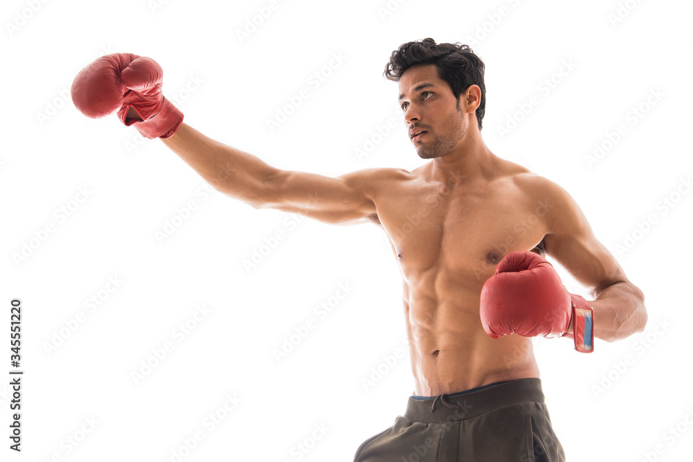 Man throwing punch in the air while wearing boxing gloves in front of a ...