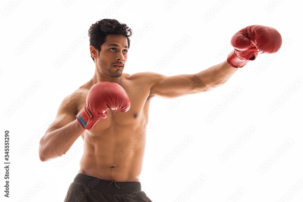 Man throwing punch in the air while wearing boxing gloves in front of a ...