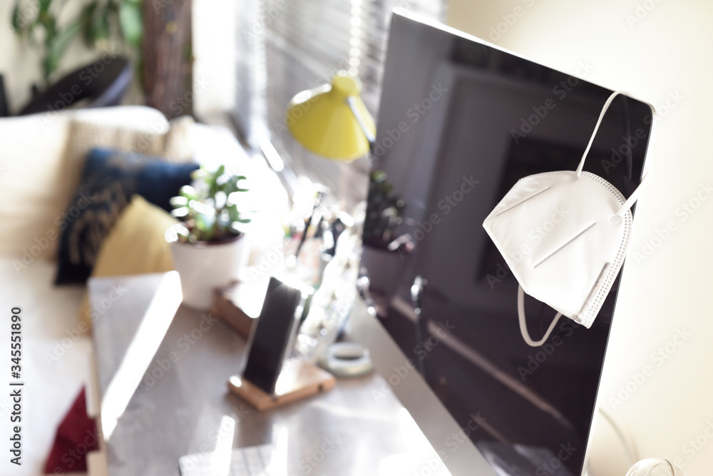Home office with face mask representing work from home during period of ...