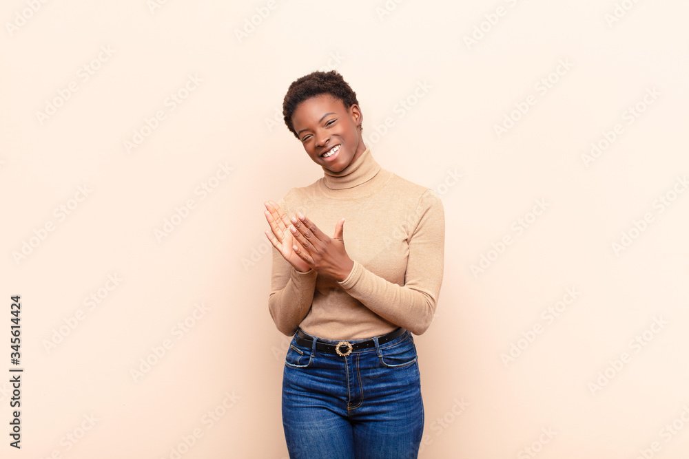 young pretty black womanfeeling happy and successful, smiling and ...