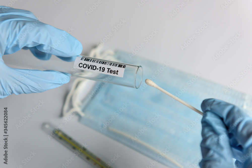 Hands in medical gloves holding COVID-19 swab. Test tube for taking ...