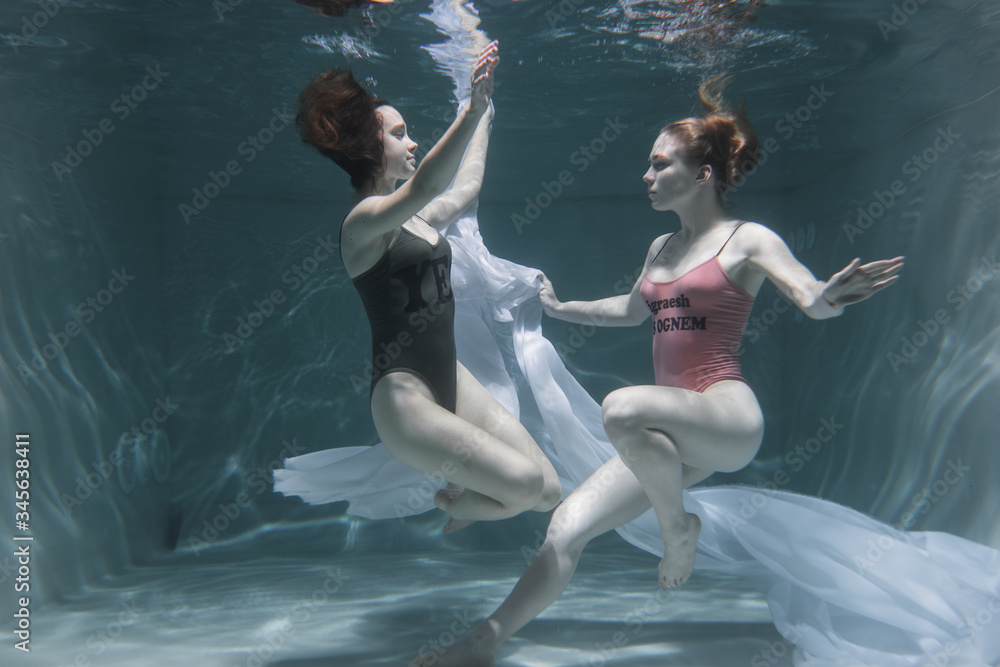 Two beautiful lesbian girls are swimming underwater. Attractiveness ...