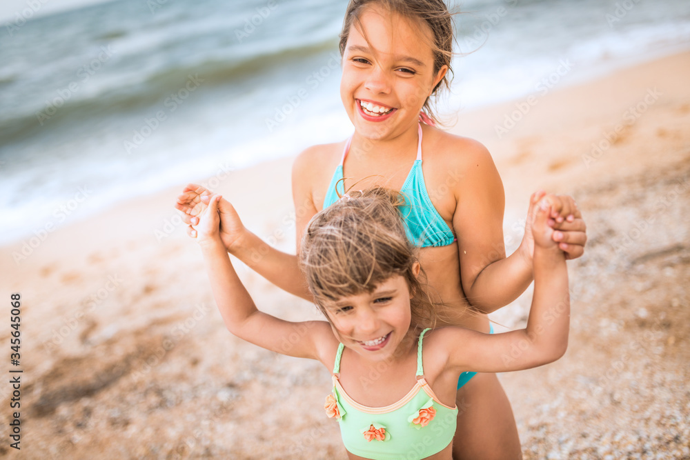 Two Cute Positive Little Girls Sisters Raised Their Hands Up While