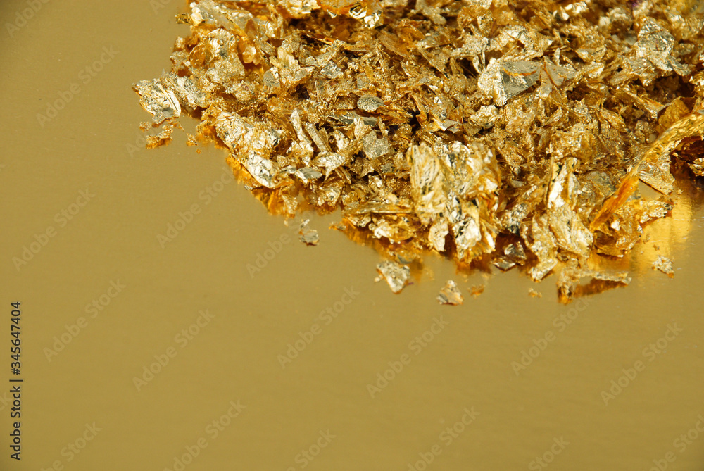 Gold flakes on a gold foil shiny background Stock Photo | Adobe Stock