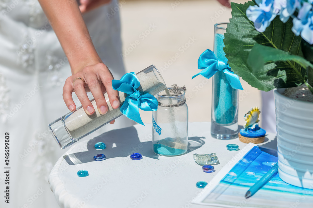 Bride and groom pouring colorful different colored sands into the ...