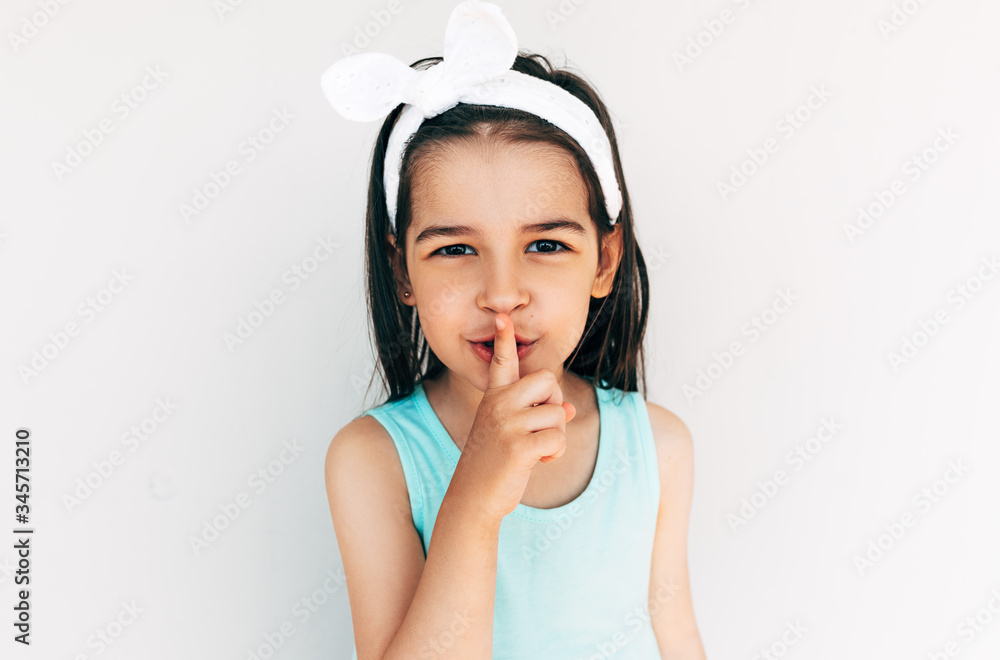 Closeup portrait of little girl wearing blue dress, white bow showng ...