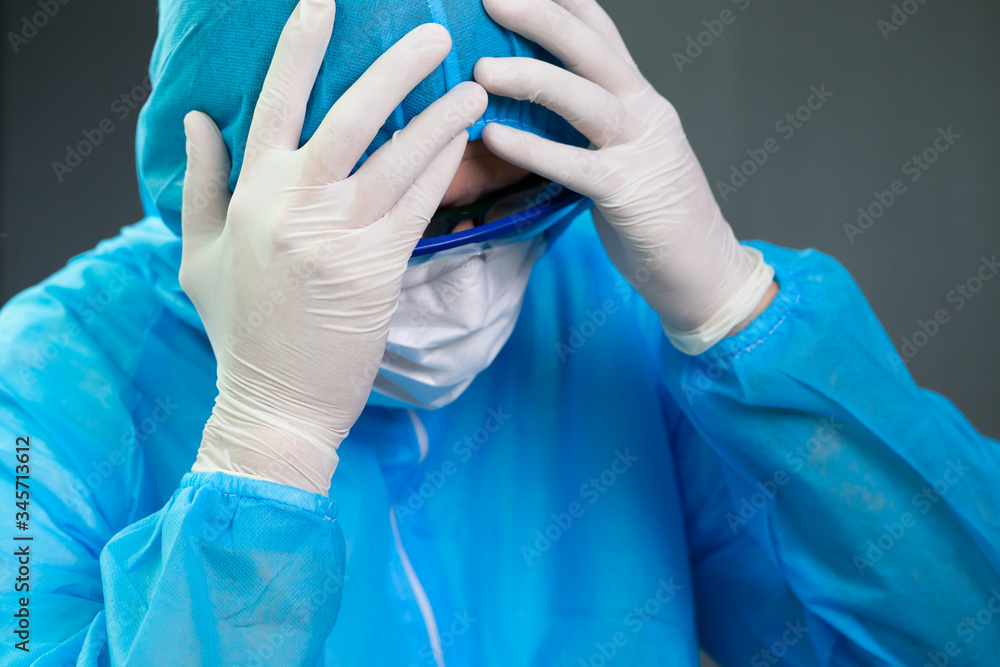 Doctor wearing PPE suit uniform is stressed and headache after long ...