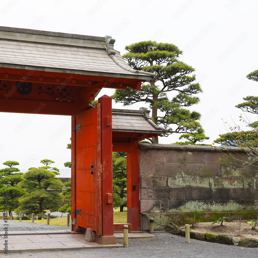 Red Asian gate to a Japanese garden on a background of green ...
