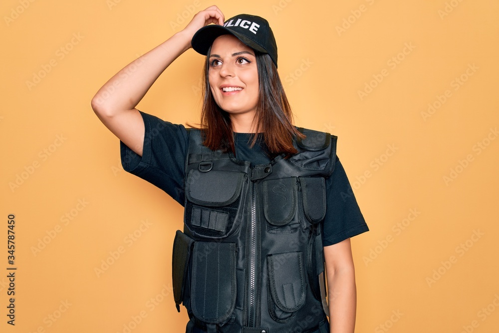 Young beautiful brunette policewoman wearing police uniform bulletproof ...