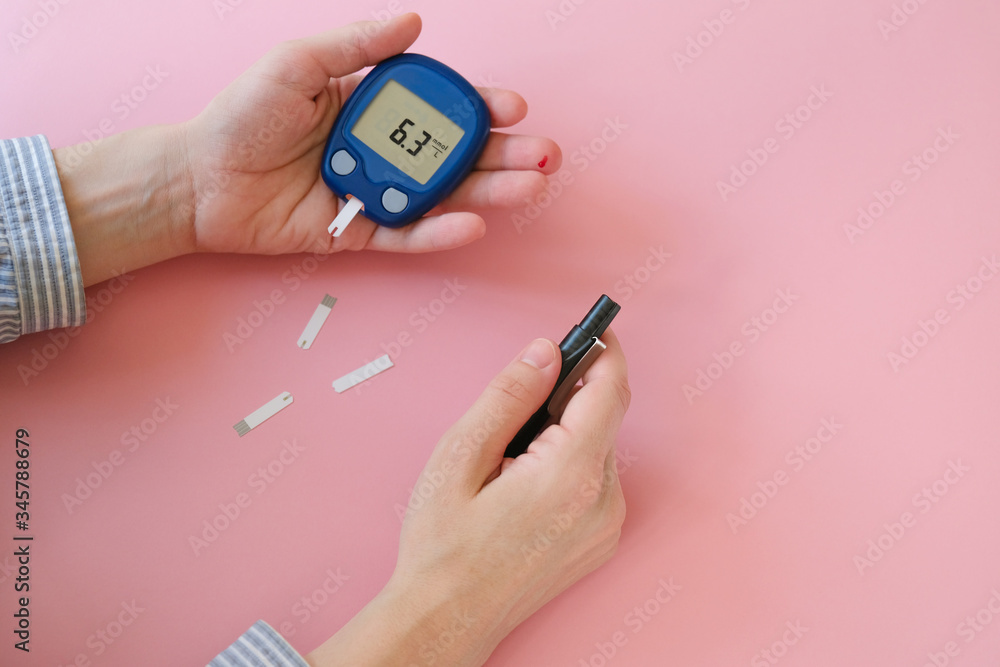 Woman doing blood glucose measurement using glucometer. Diabetes ...
