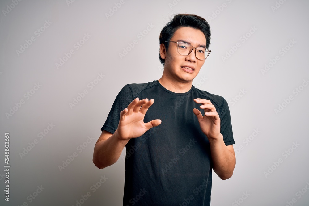 Young handsome chinese man wearing black t-shirt and glasses over white ...