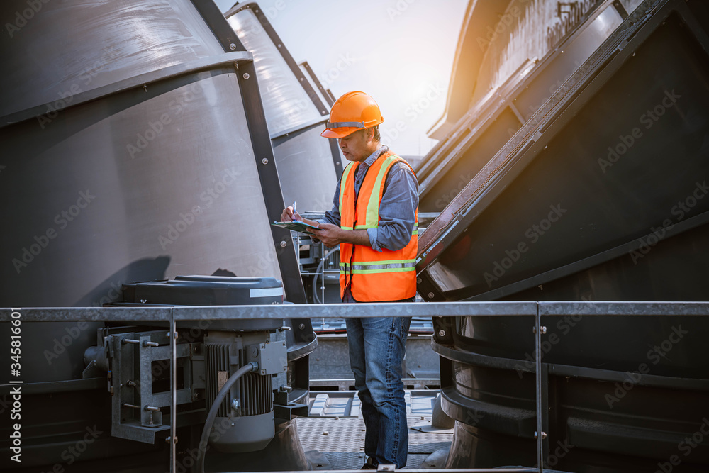A engineer under checking the industry cooling tower air conditioner is ...