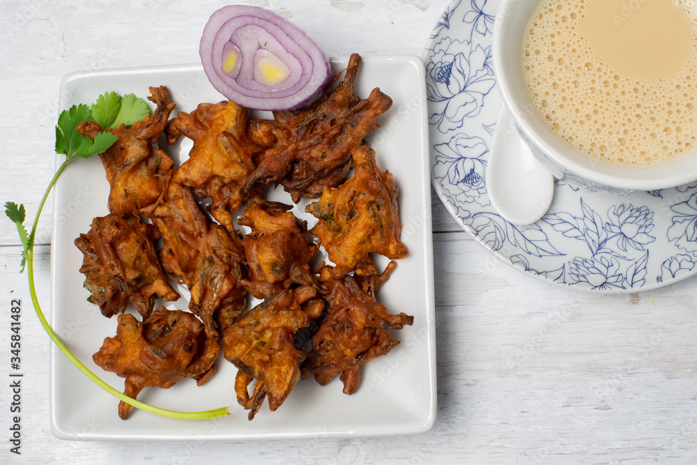 Traditional snack named Onion pakoda from Kerala with cut onion along ...