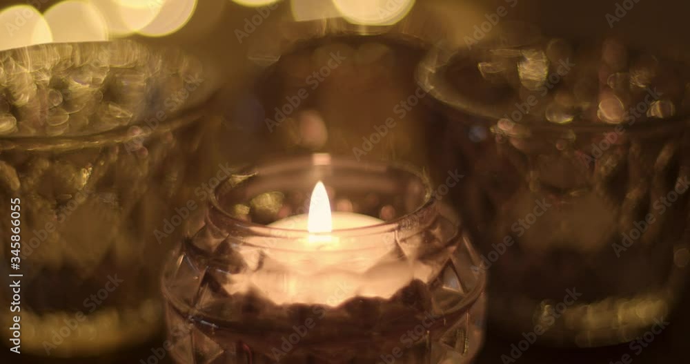 Tilt of a tealight candles in glass holders with bokeh background Stock ...