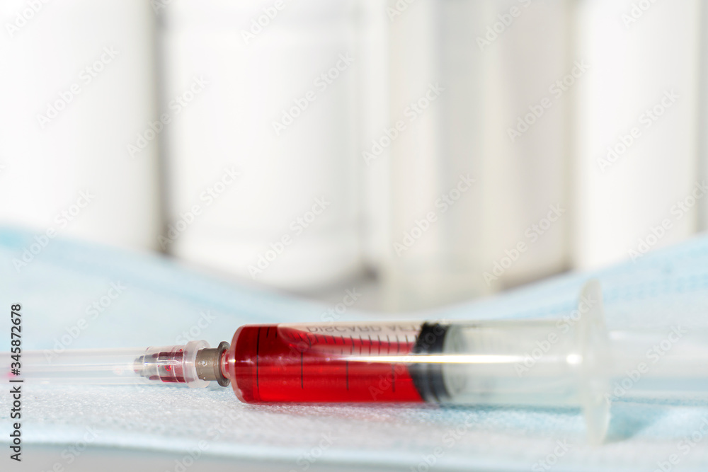 tablets in jars, antiseptic gel, disposable mask, syringe with a red ...