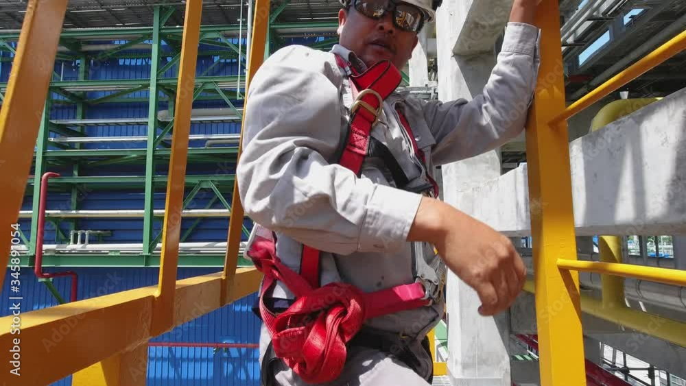 Engineers wear a full body safety harness and climb up the vertical ...