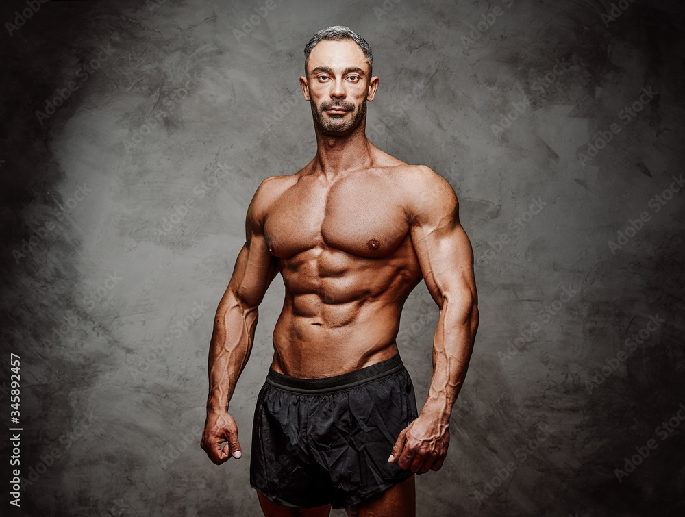 Shirtless adult male bodybuilder posing for a photoshoot shirtless in a ...