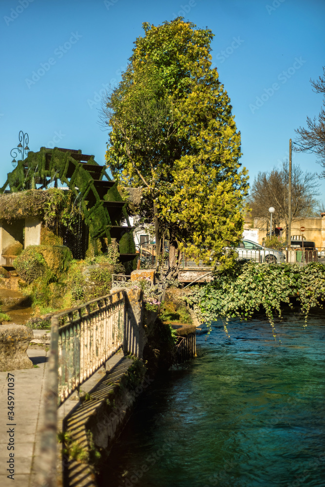 Vertical view of wheel of water mill in Medieval village L'Isle-sur ...